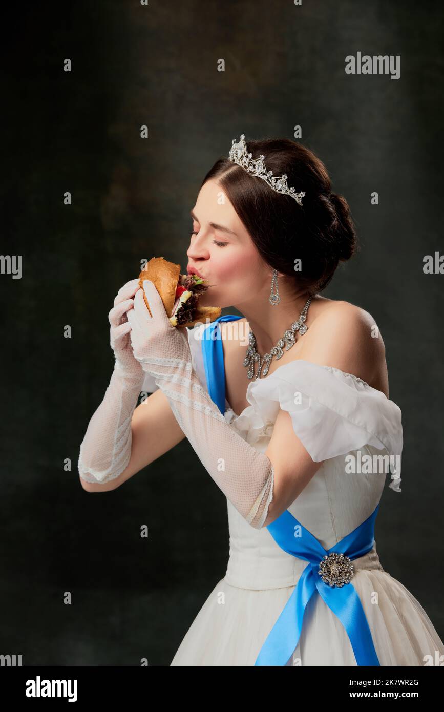 Enjoy the taste. Beautiful young queen or princess in white medieval ...