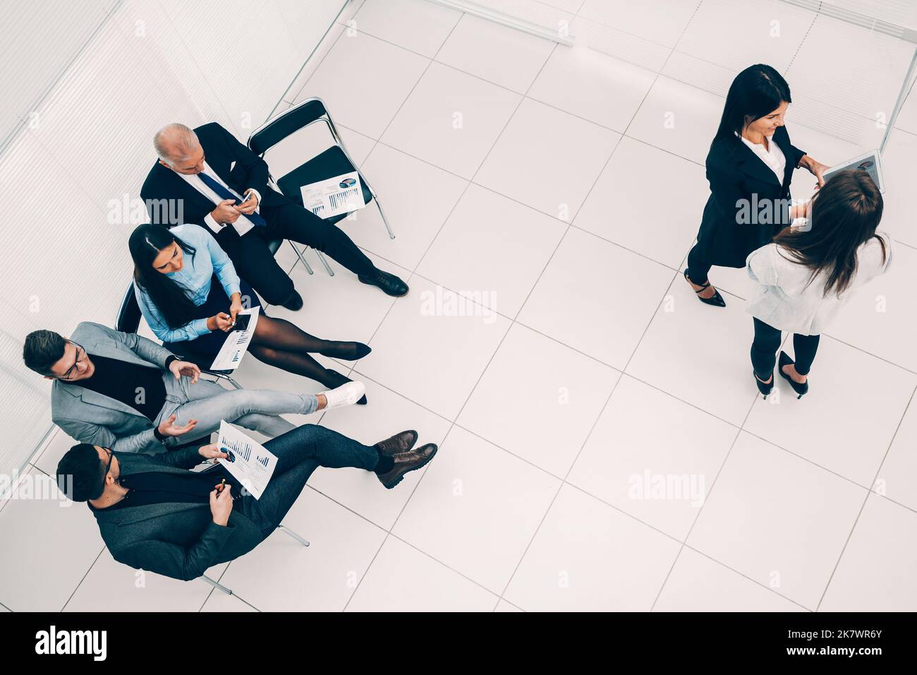 top view. a group of employees using their devices in the workplace ...