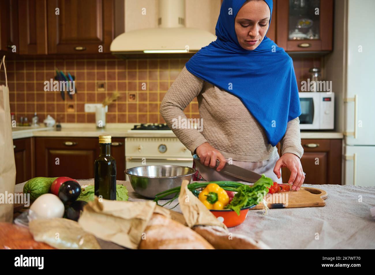 Beautiful Arab Muslim woman, pretty housewife in blue hijab, preparing ...