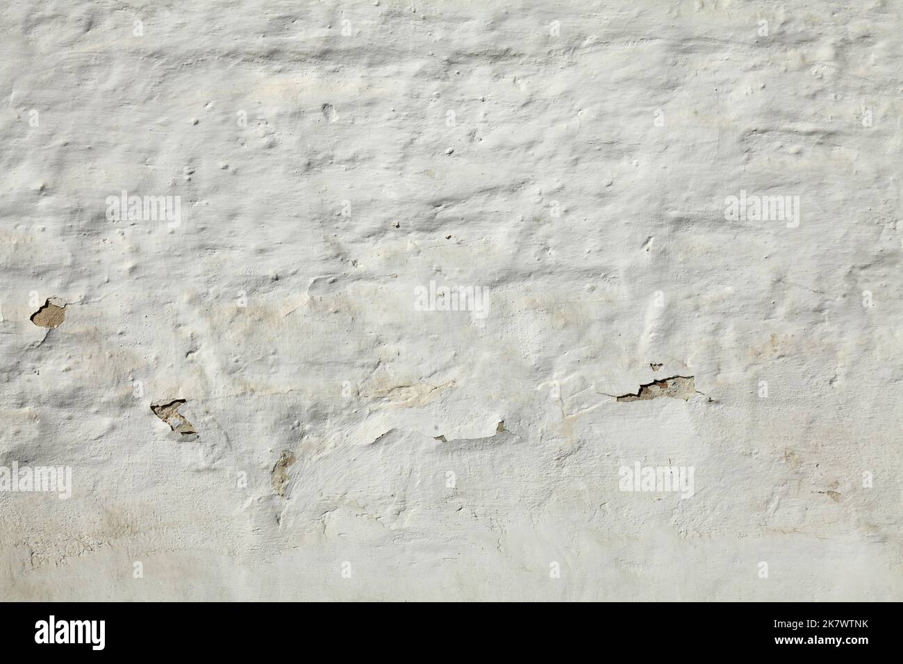 Old and cracked, dilapidated and uneven brick wall, painted with ...