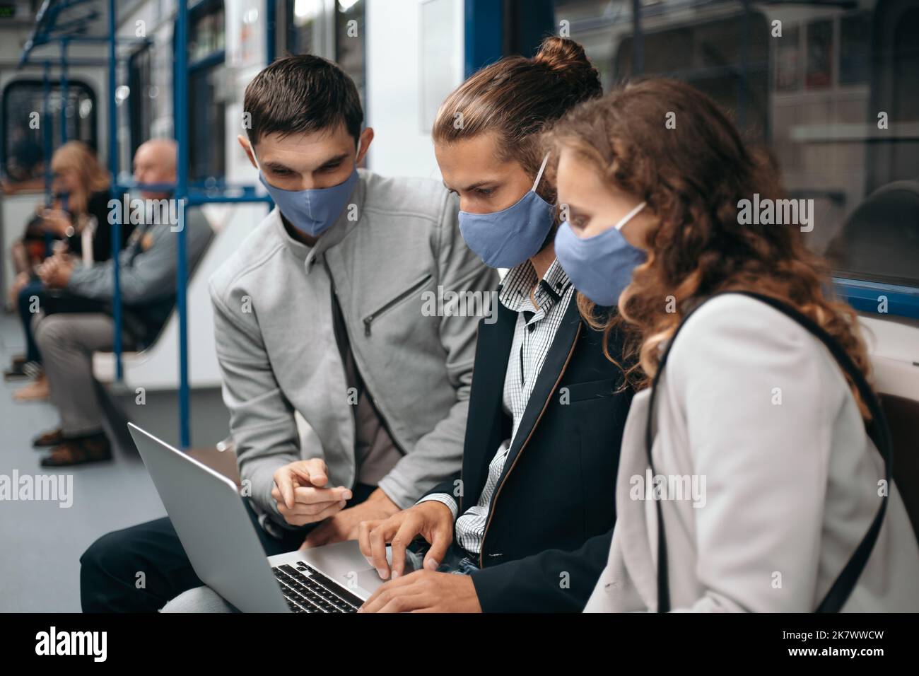group of young people discussing online news while sitting in a subway ...