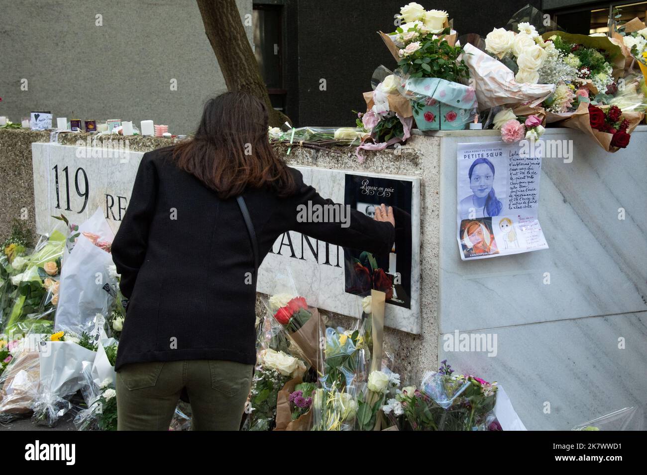 Flowers, messages and candles are seen in front of the building where ...