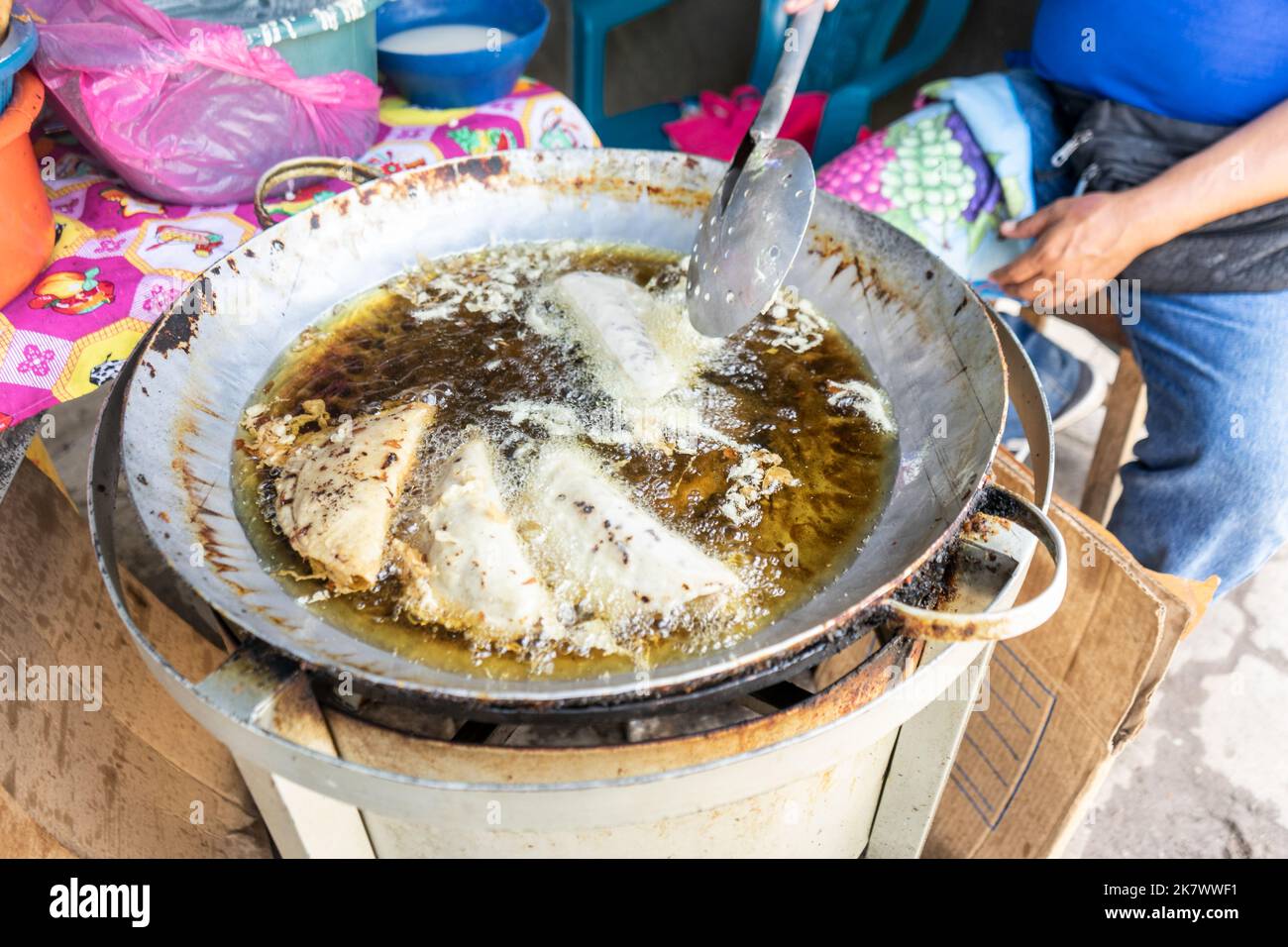Nicaraguan man frying enchiladas on the street. street food in latin ...