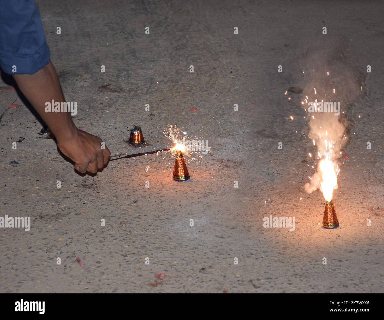 Hand of a child lighting up a flower pot cracker during Diwali night in ...