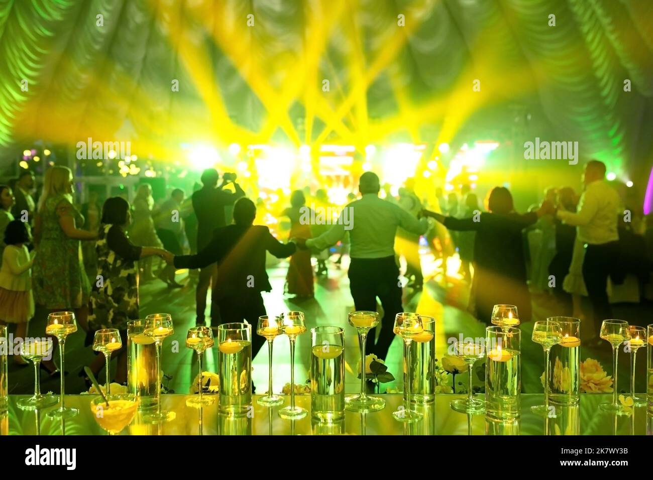 Wedding decoration glass table with dancing blurred people background ...