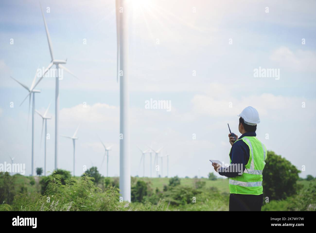 Engineer man stand holding tablet front the wind turbines generating ...
