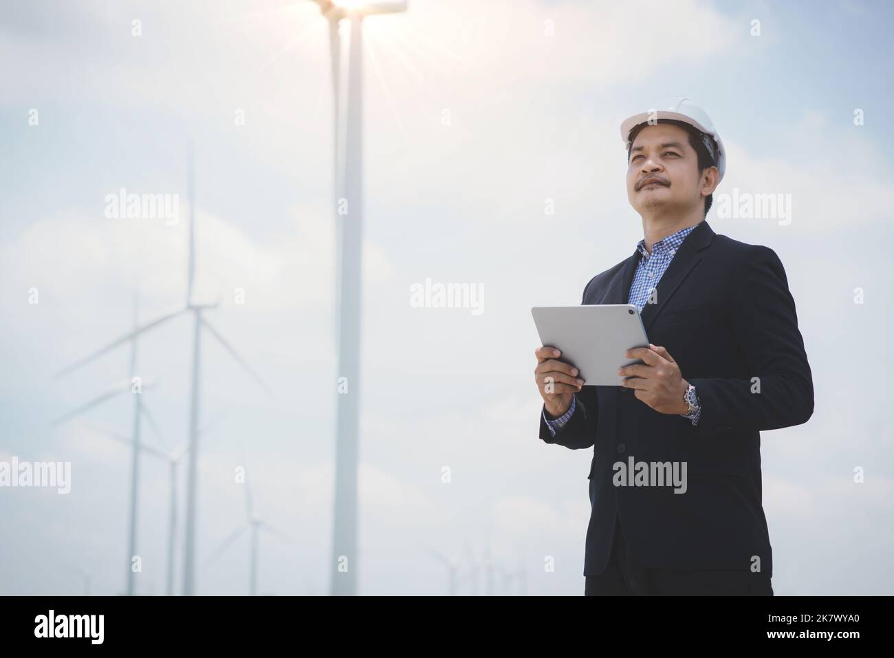 Engineer man manager in suit stand holding tablet front the wind ...