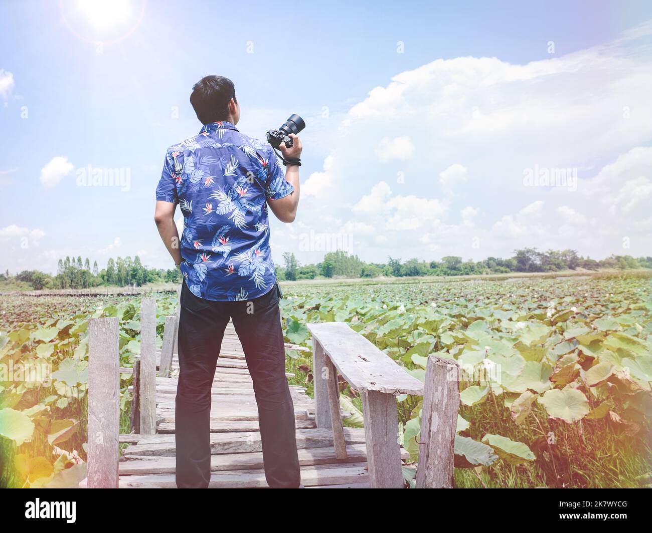 The traveler man holding the camera and standing on the old bridge with ...