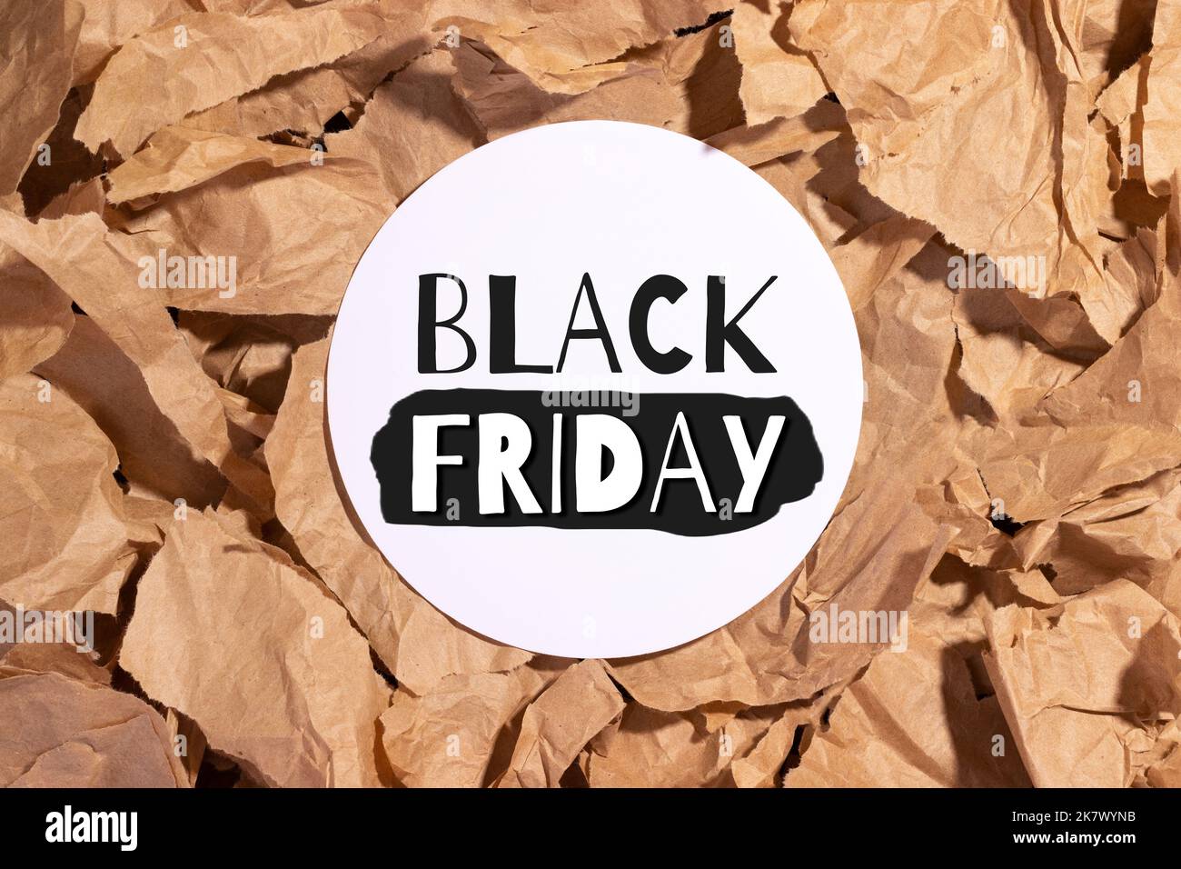 Black Friday sign on white circle on multiple pieces of torn brown ...