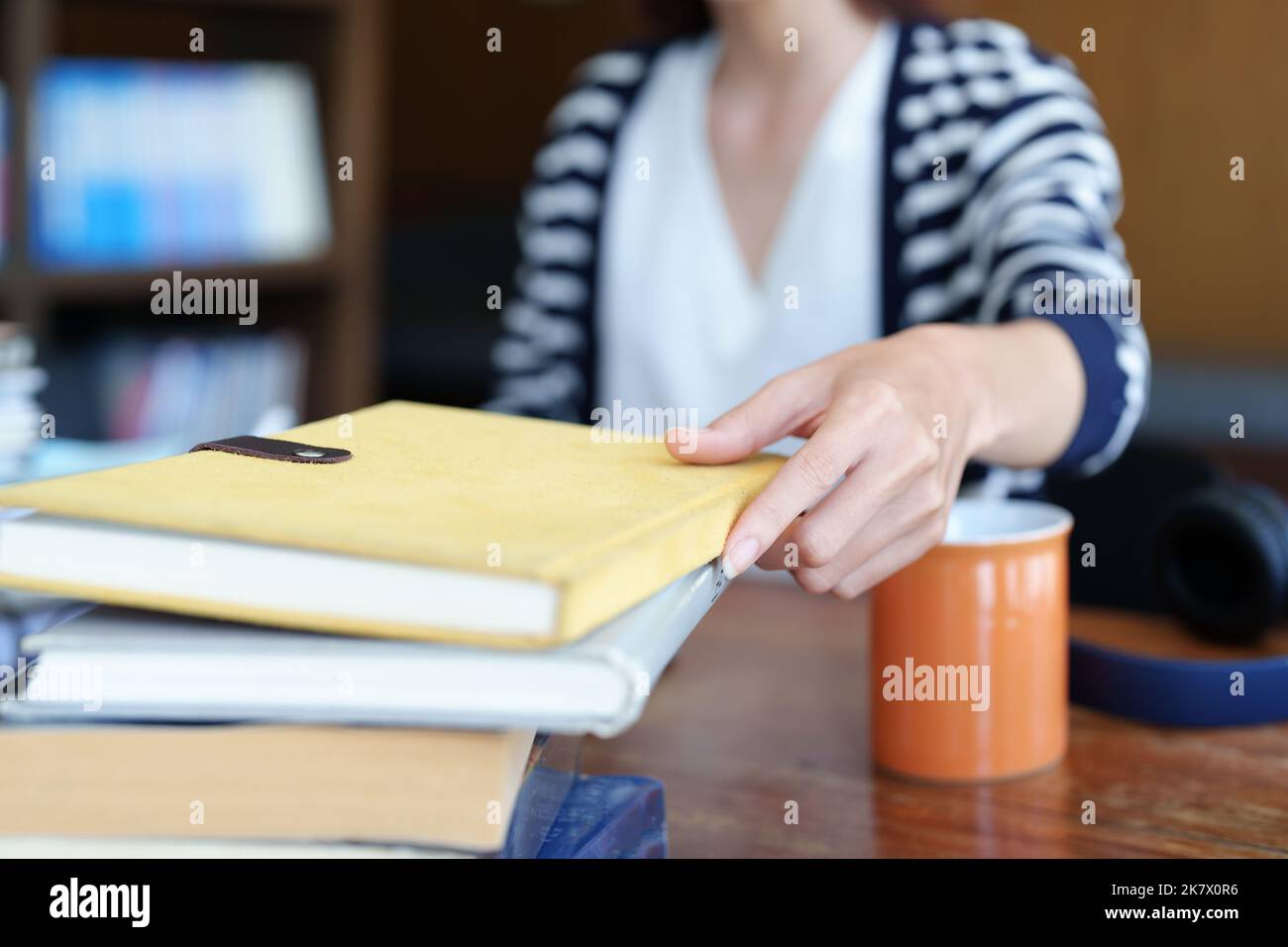 A portrait of a young Asian woman with a smiling face picking up a ...