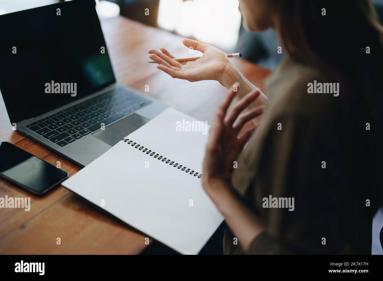 Portrait of a smiling Asian teenage girl wearing headphones and using a ...