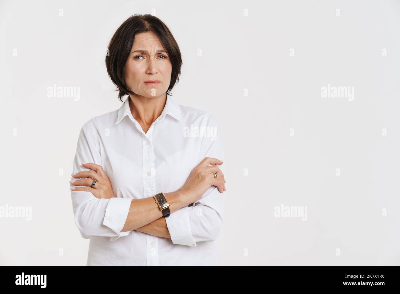 Mature woman frowning while posing with arms crossed isolated over ...