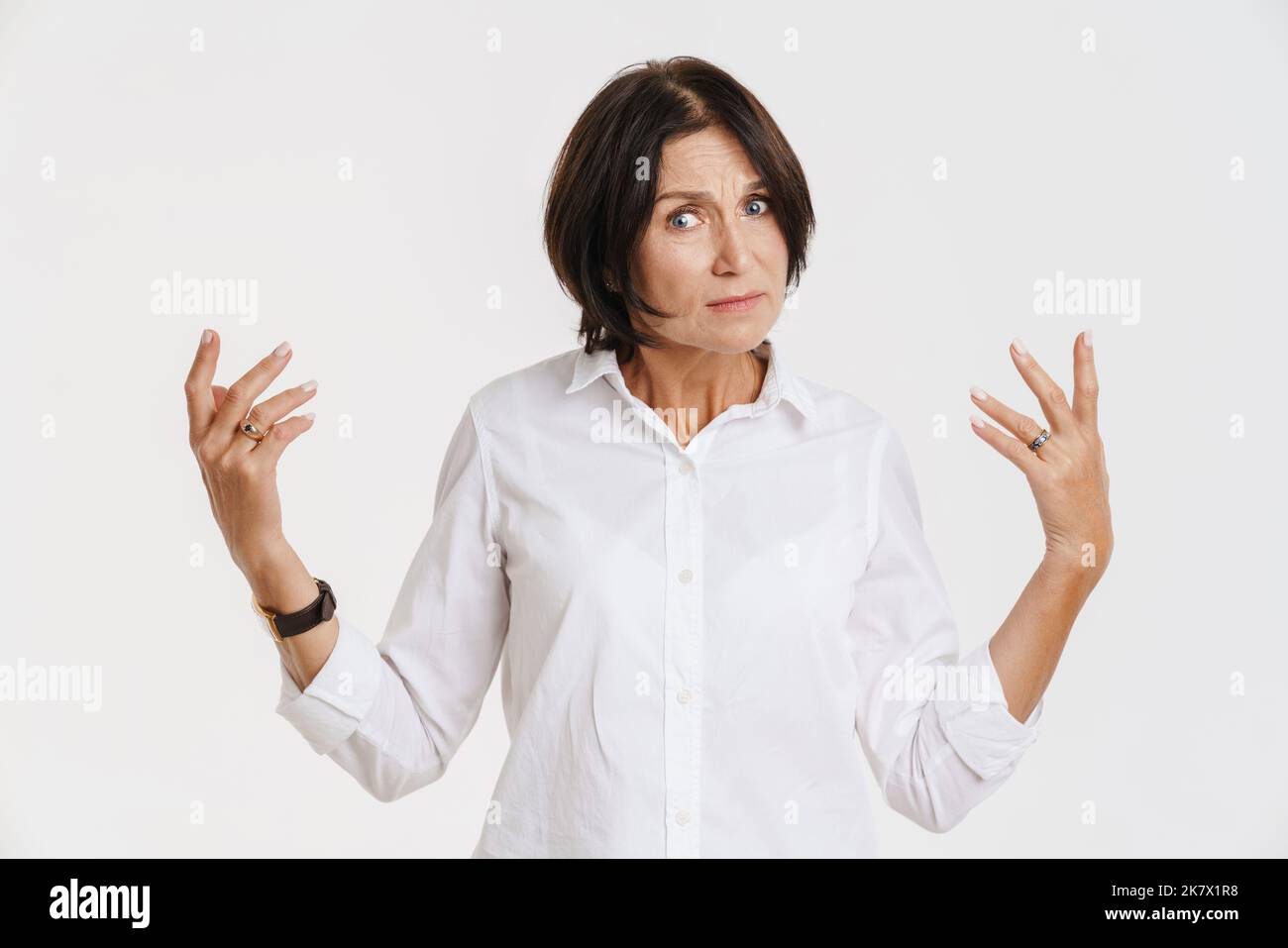 Mature brunette woman frowning and gesturing at camera isolated over ...
