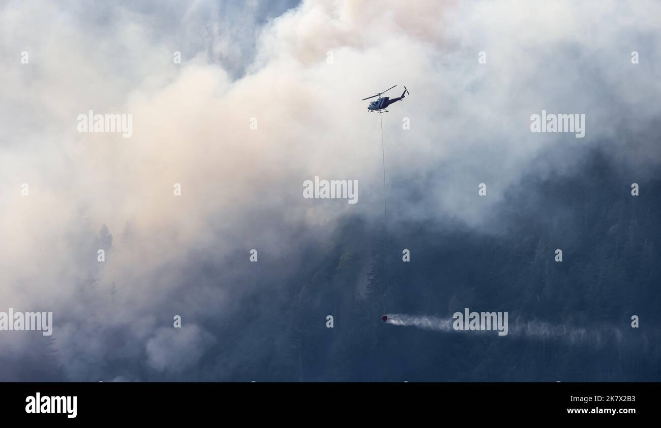 Wildfire Service Helicopter flying over BC Forest Fire and Smoke on the ...