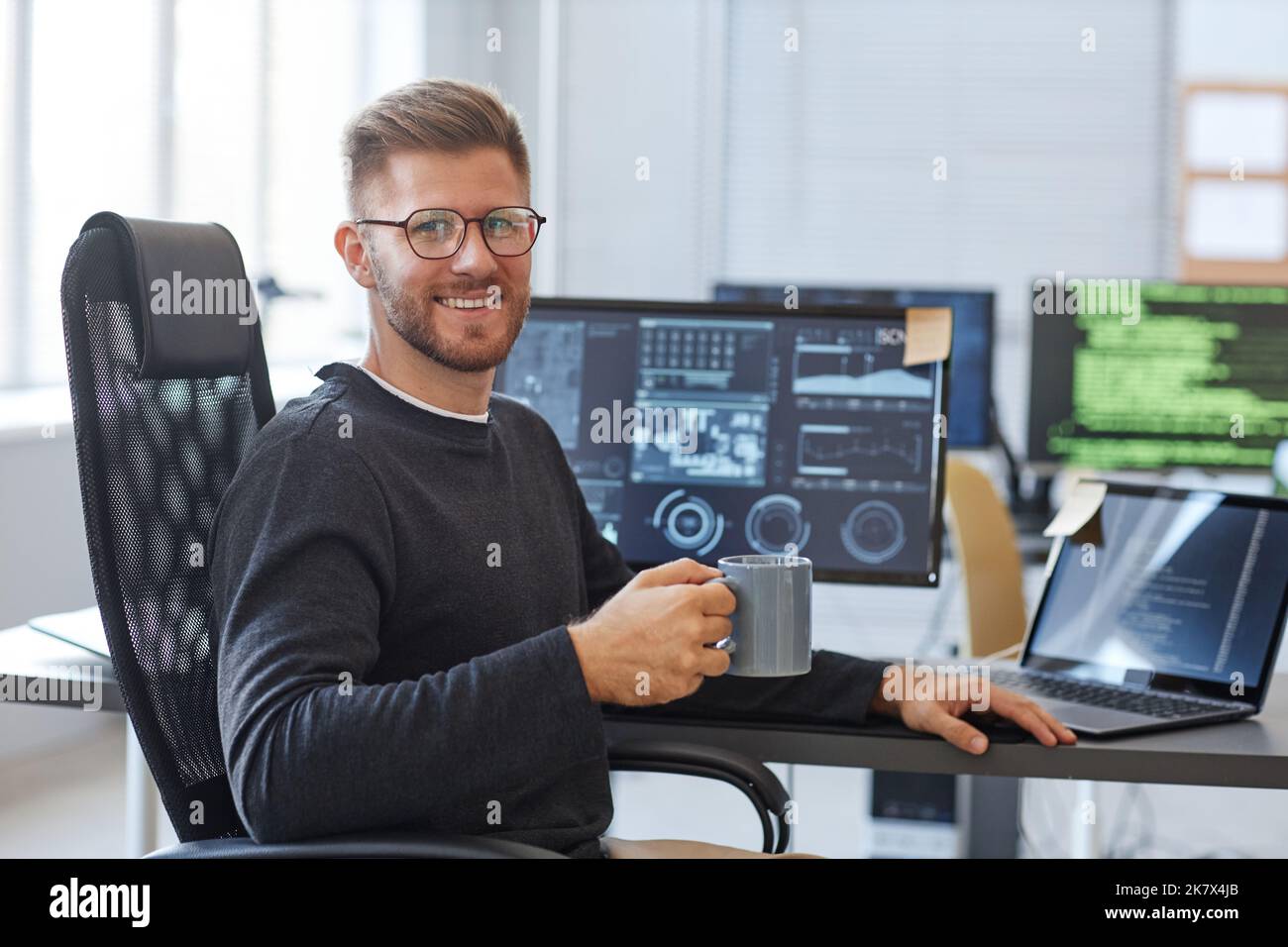 Portrait of software programmer smiling at camera while posing at ...