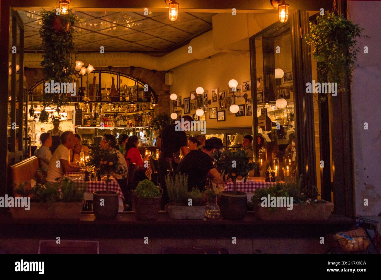 busy restaurant interior seen through the open window from outside ...