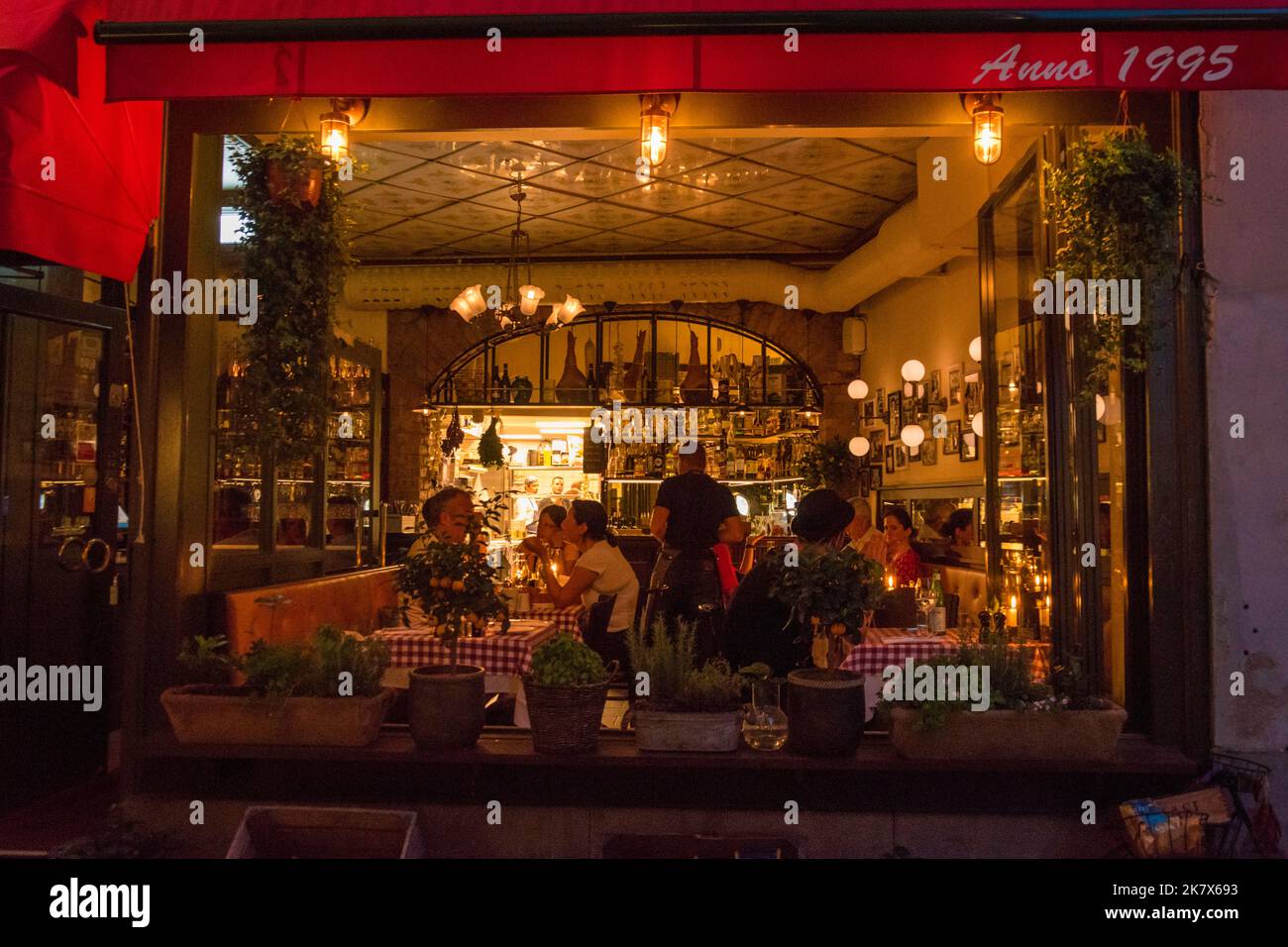 busy restaurant interior seen through the open window from outside ...