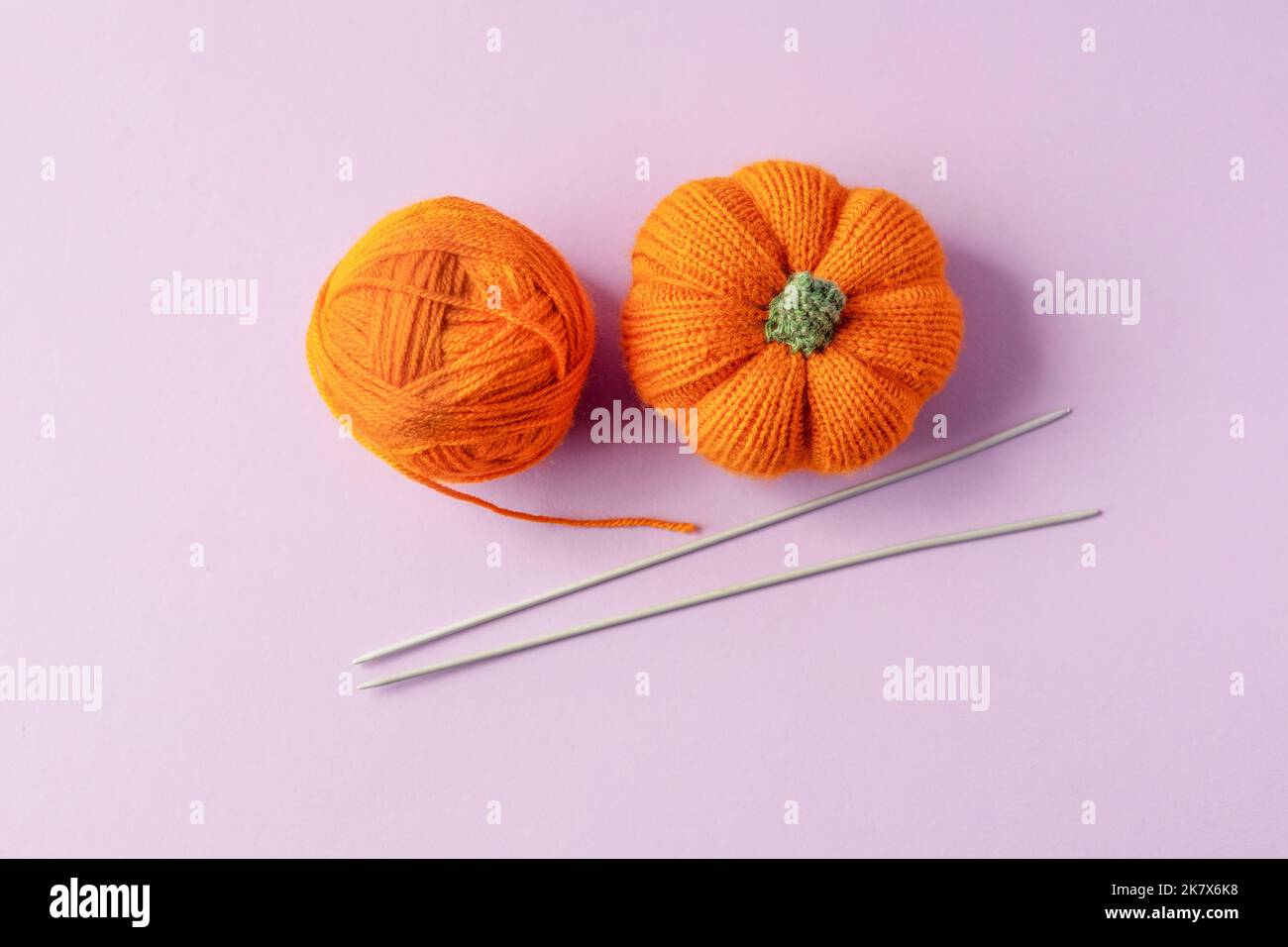Knitted orange pumpkin and an orange ball of thread with knitting ...