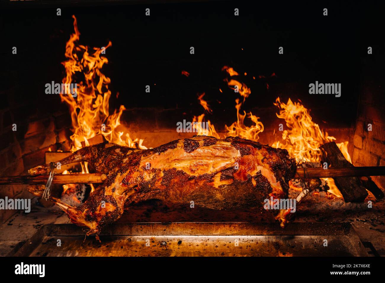 The lamb is cooked entirely on a spit on the fire. Cooking Stock Photo ...
