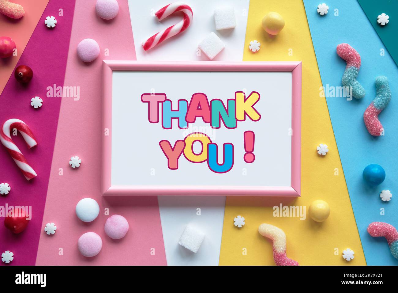 Text Thank you in frame on layered colored paper. Assorted sweets ...
