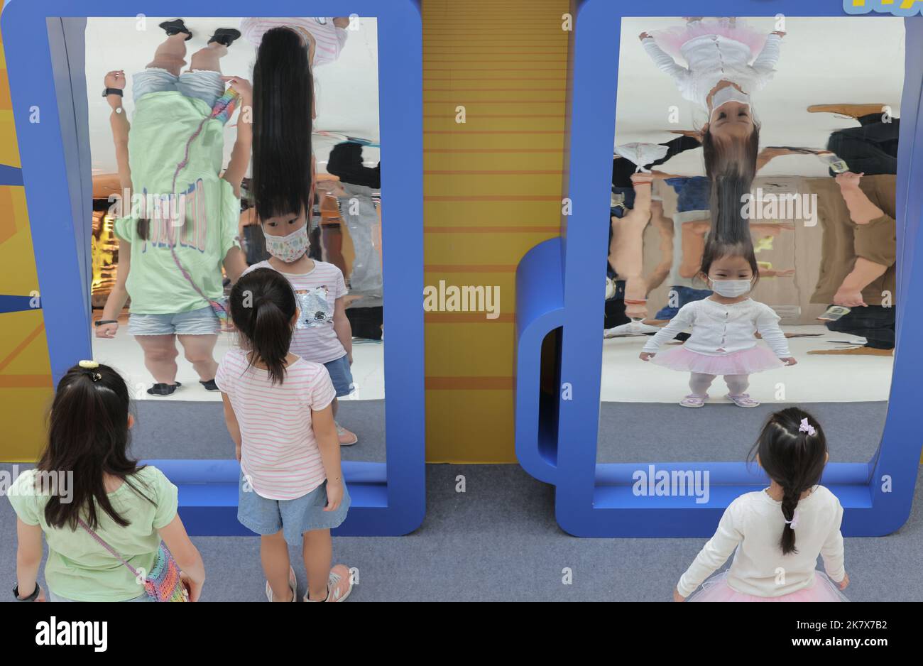 Children make various expressions on distorting mirror at the shopping ...