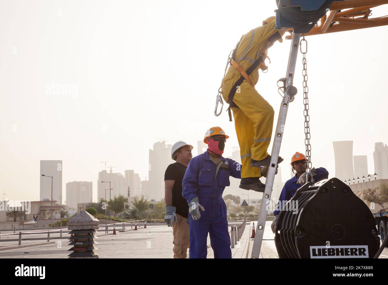Doha, Qatar, December 18,2019 : Construction workers preparing a crane ...