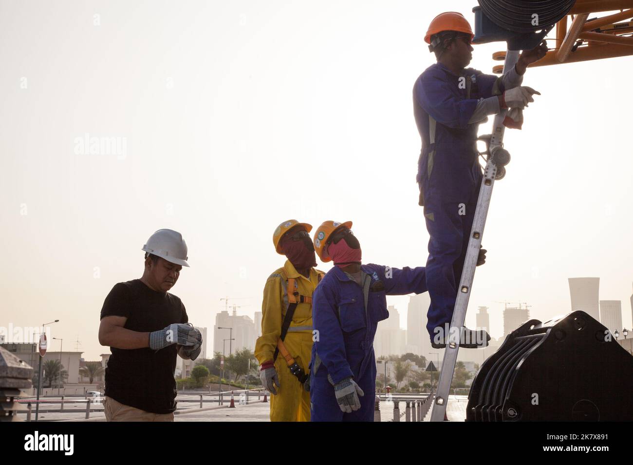 Doha, Qatar, December 18,2019 : Construction workers preparing a crane ...