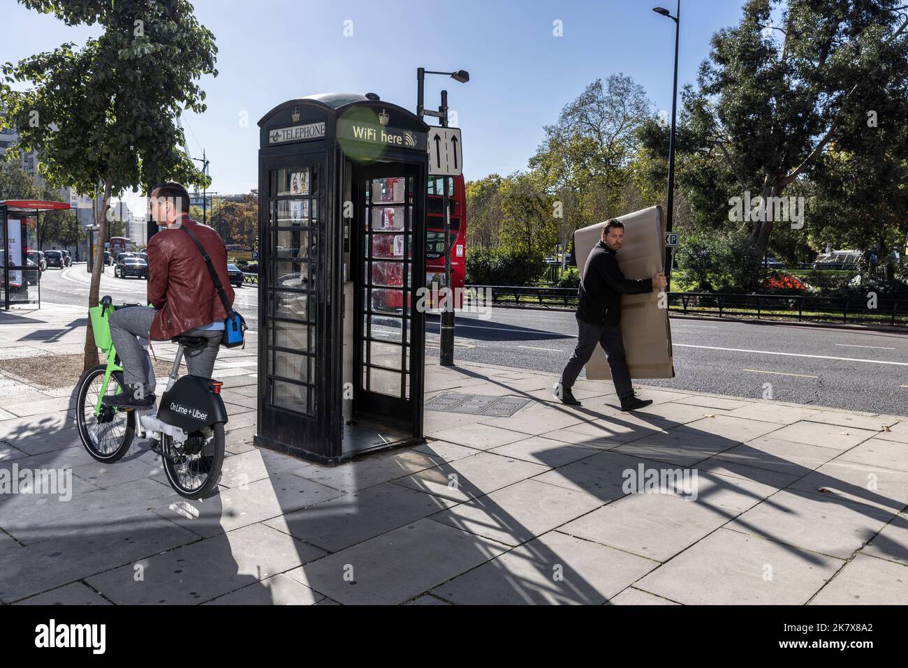 Man seen carrying large object protected by a cardboard sleeve along ...