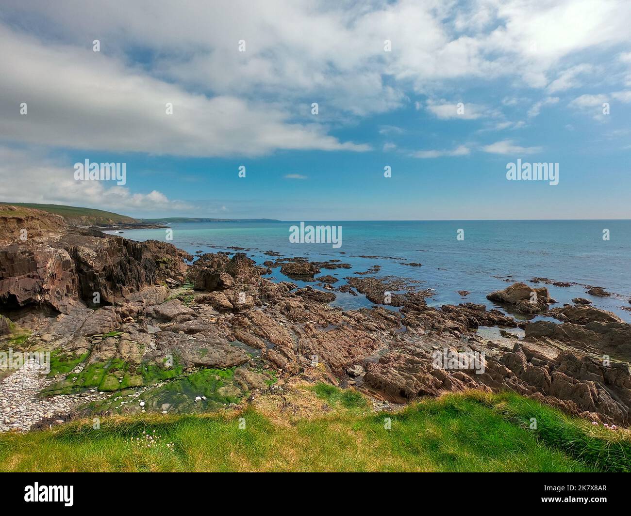 The rocky coast of the Celtic Sea on a sunny day. Clear blue sky with ...