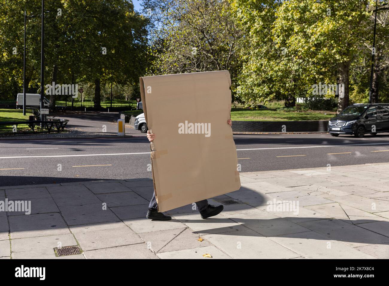 Man seen carrying large object protected by a cardboard sleeve along ...