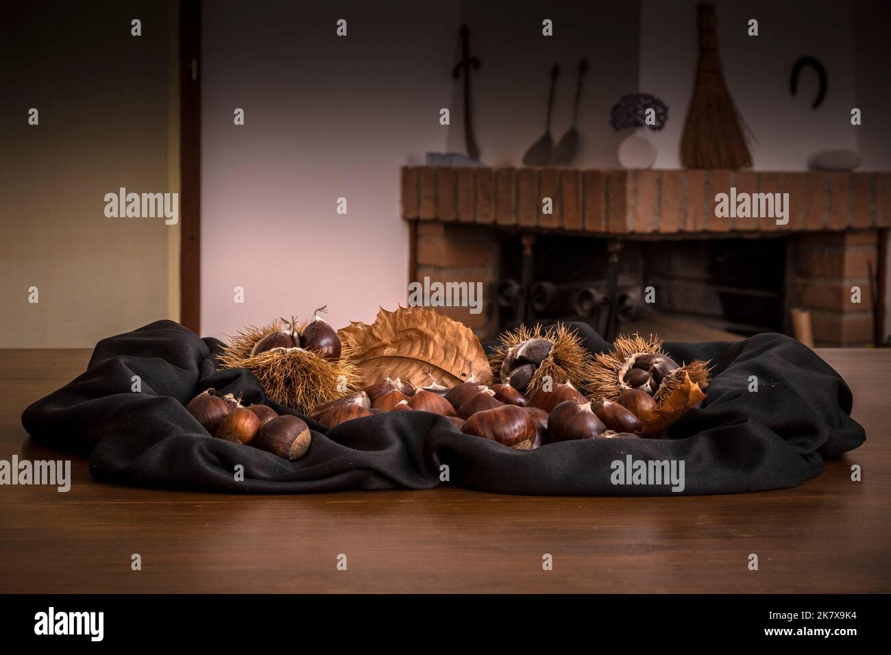 Still life of chestnuts on table with fireplace in the background Stock ...