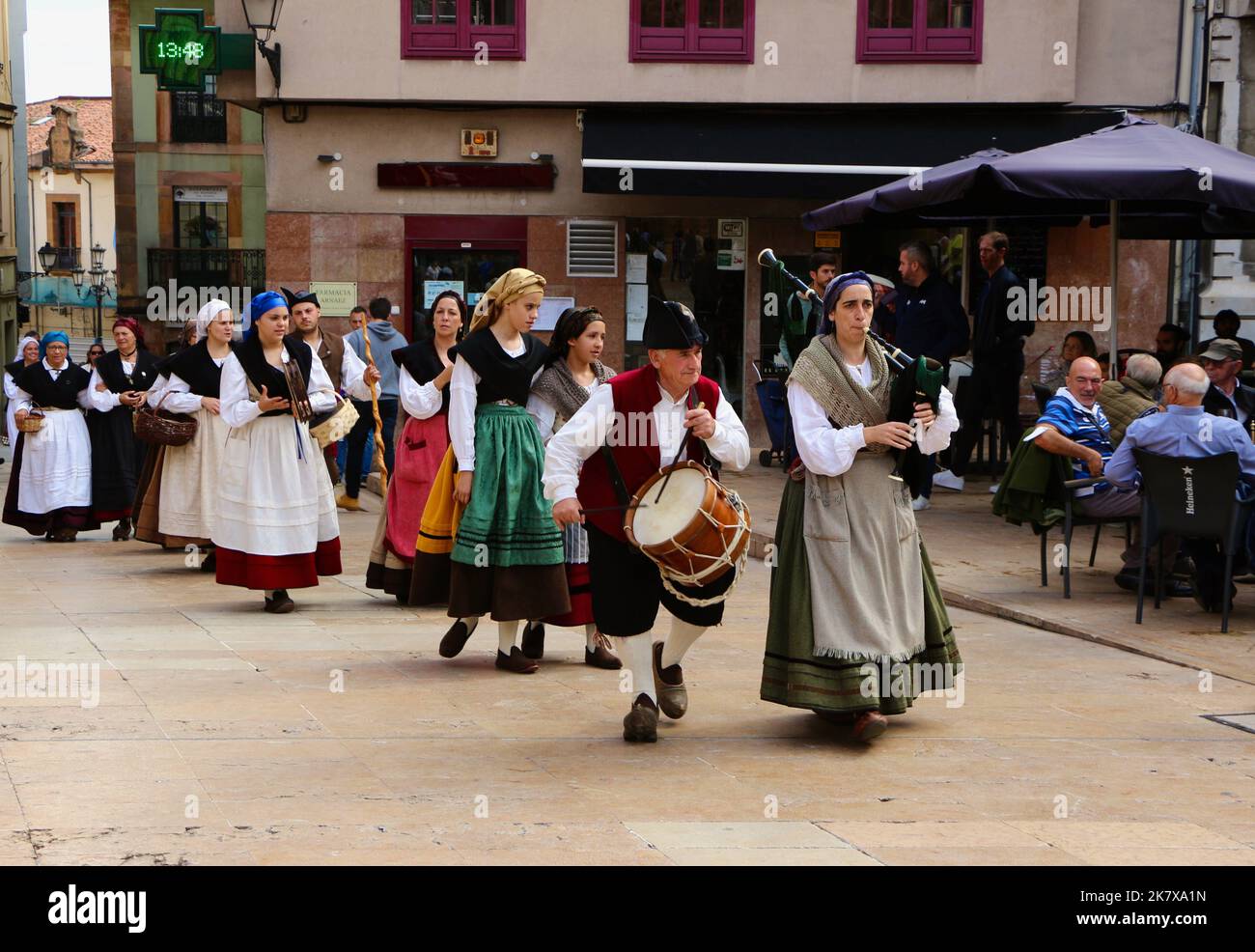 A folk dance group in traditional costumes walking in procession to ...