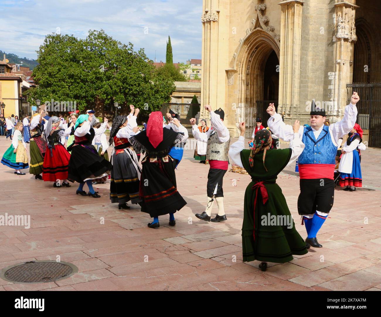 A folk dance group in traditional costumes dancing to bagpipe music in ...