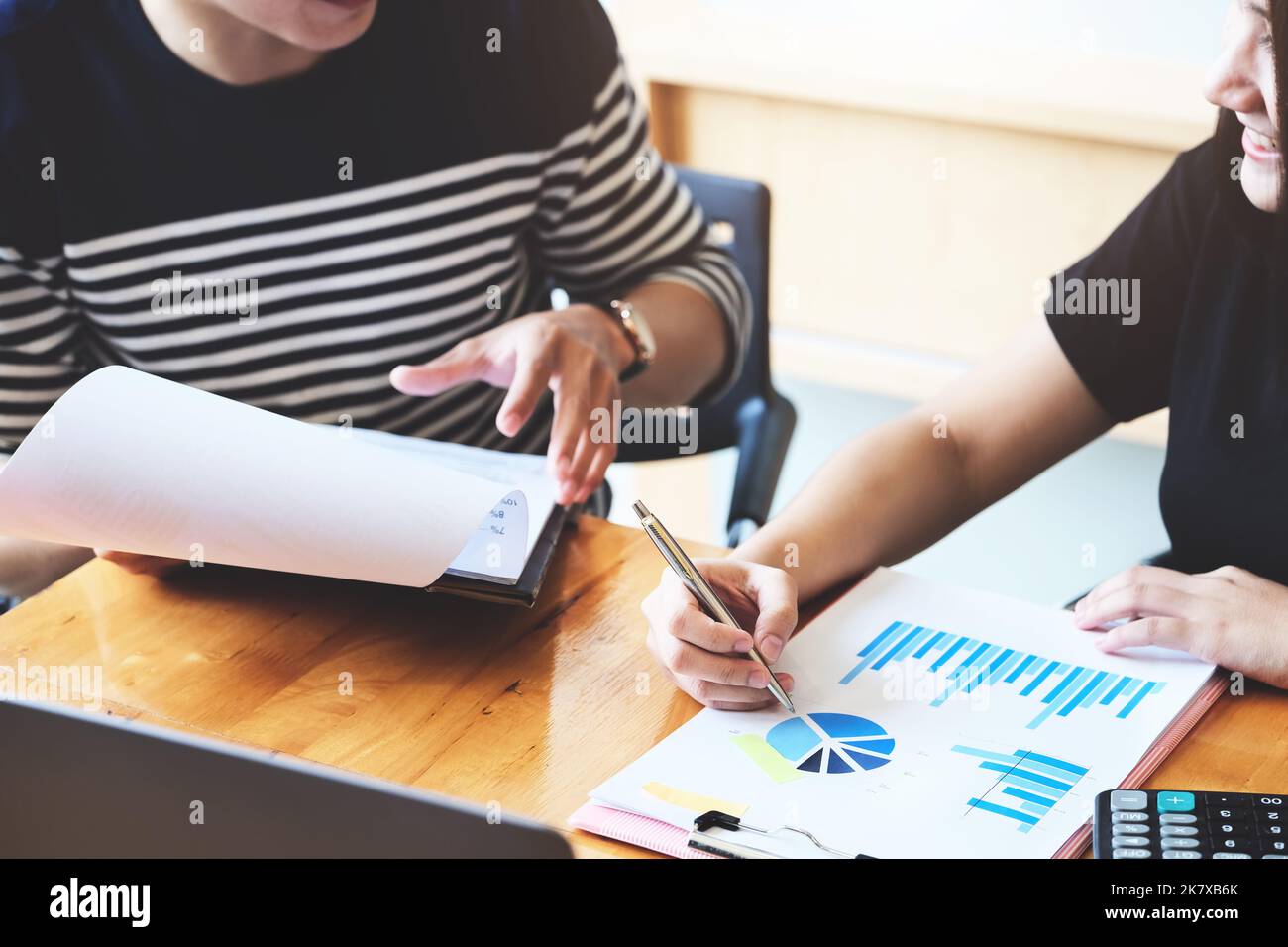 focus hand holding pen point to chart document with business woman and ...