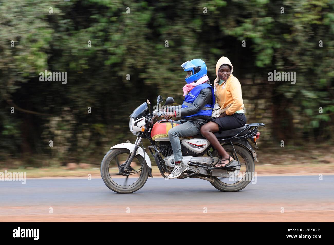 A pillion passenger riding on motorcycle taxis, know as a Boda boda, in ...
