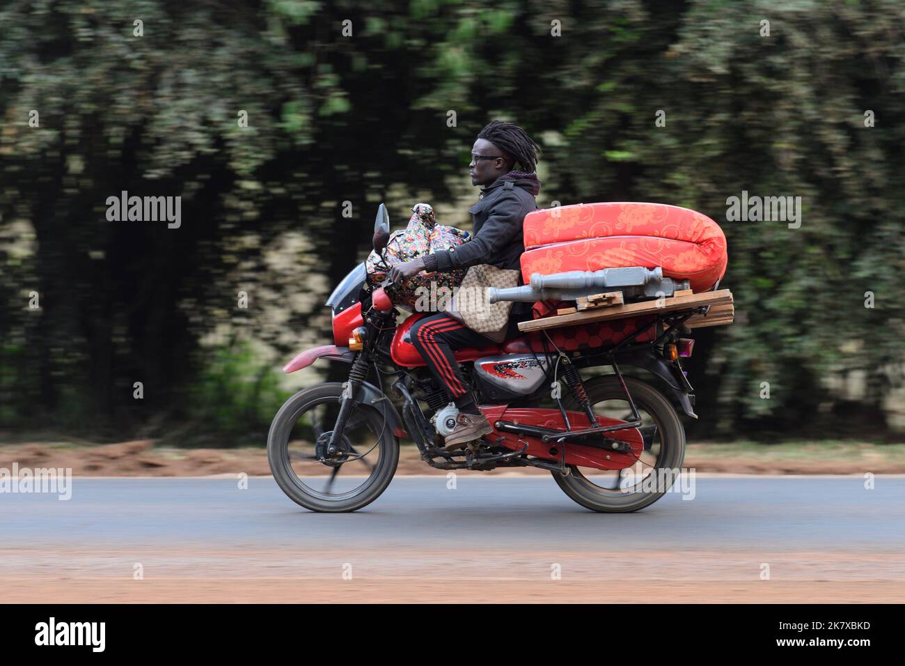 A motorcycle taxis, know as a Boda boda, in East Africa, transporting a ...