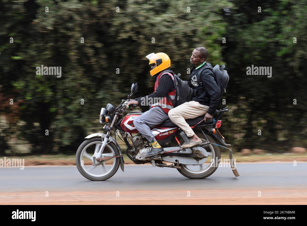 A pillion passenger riding on motorcycle taxis, know as a Boda boda, in ...