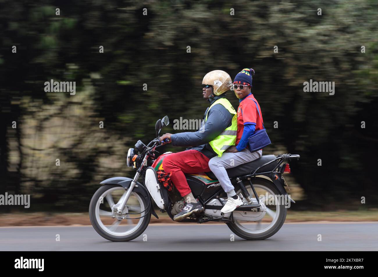 A pillion passenger riding on motorcycle taxis, know as a Boda boda, in ...