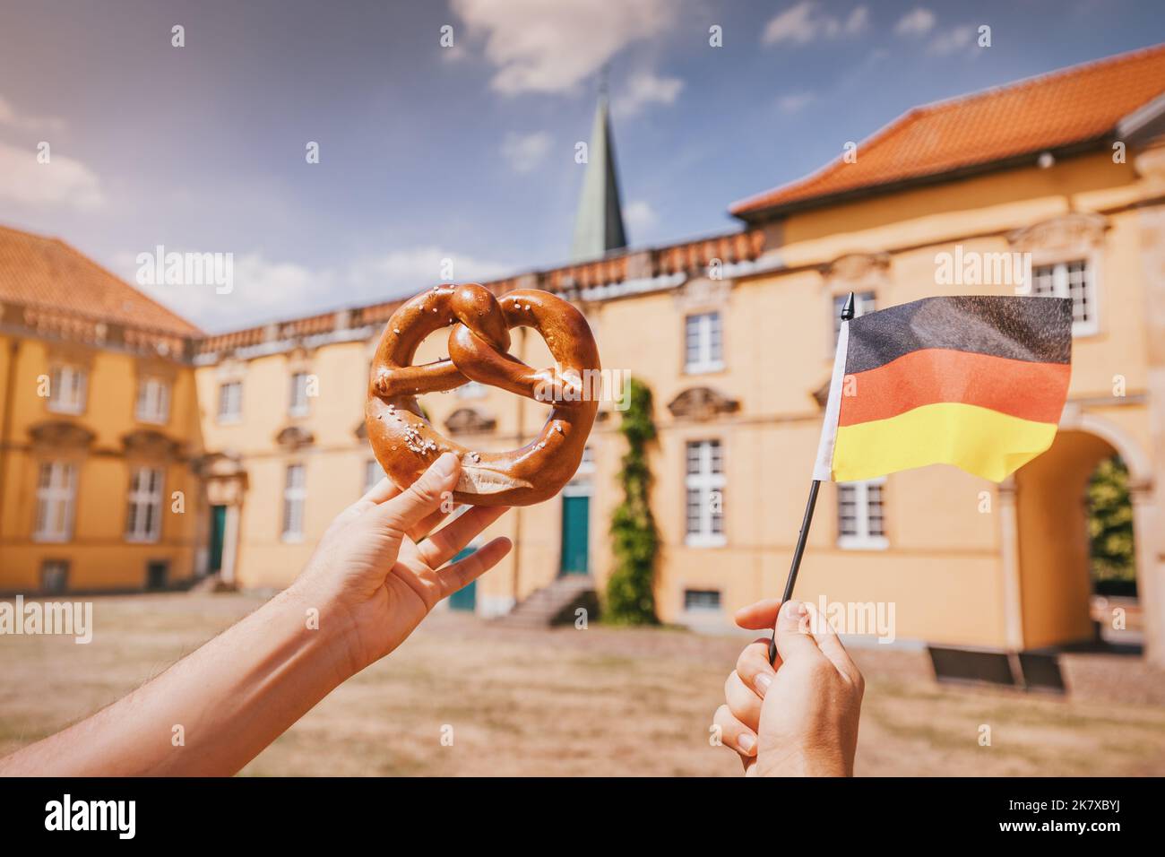 Male hand with german traditional pretzel on the background of an old ...