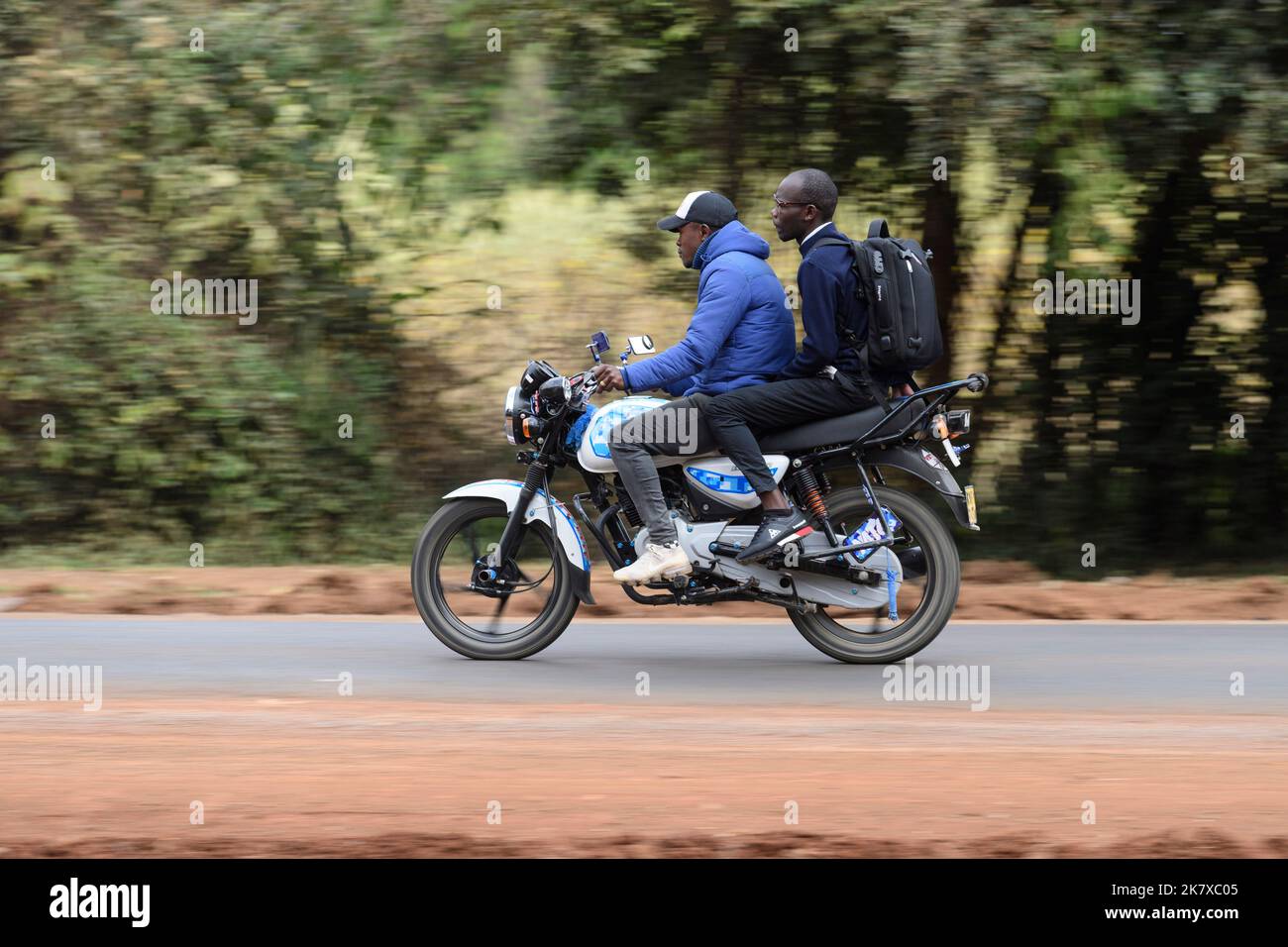 A pillion passenger riding on motorcycle taxis, know as a Boda boda, in ...