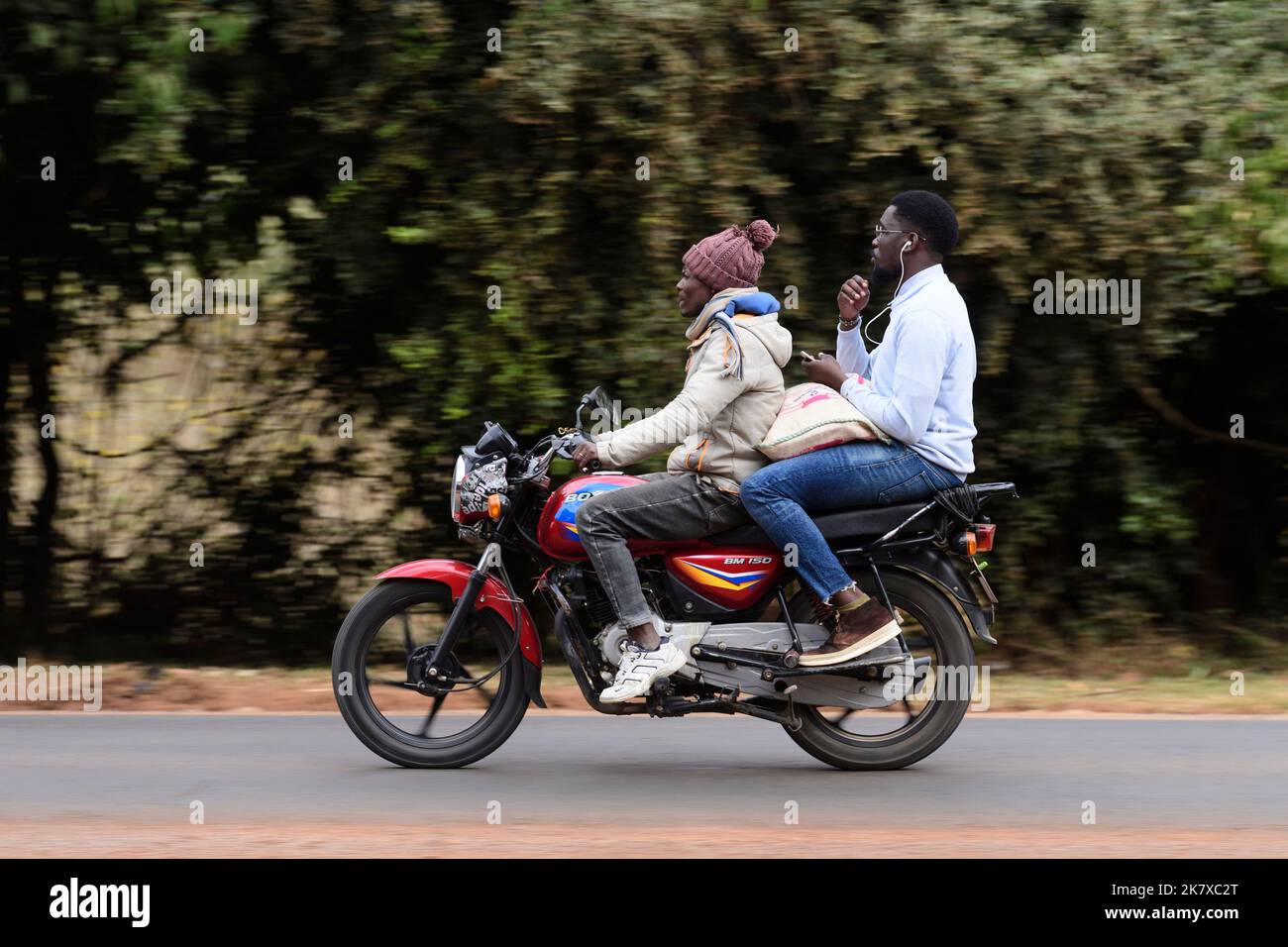 A pillion passenger riding on motorcycle taxis, know as a Boda boda, in ...