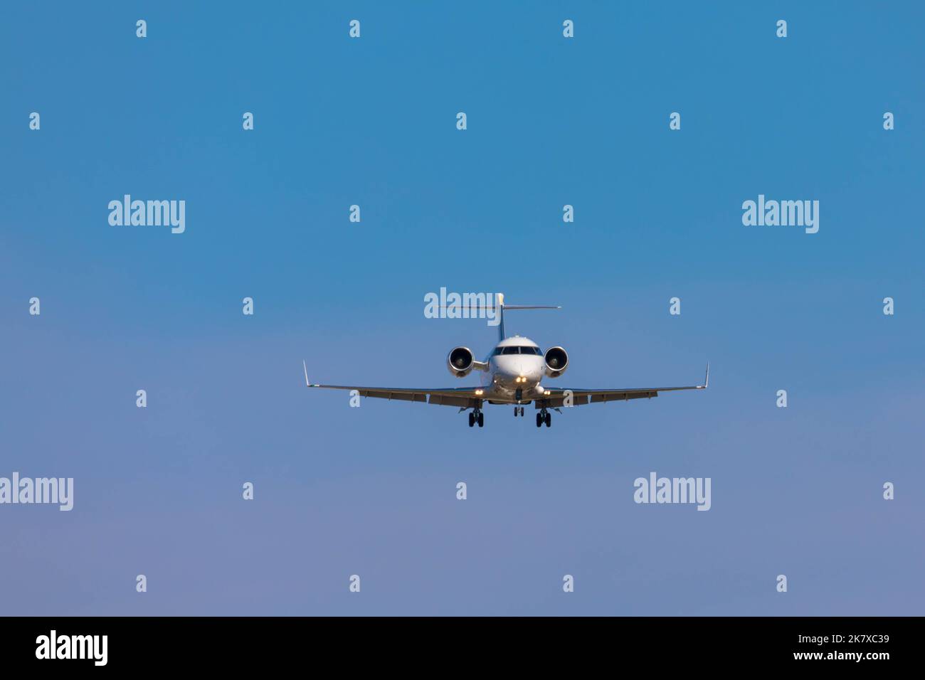 Private jet on approach for landing. Blue sky with plenty of space for ...