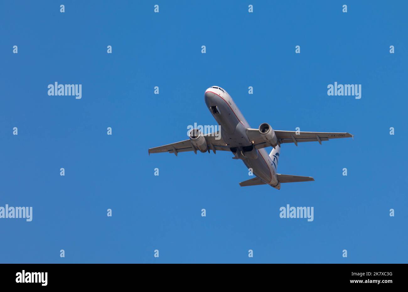 Airplane from Aegean Airlines on approach for landing. Blue sky with ...