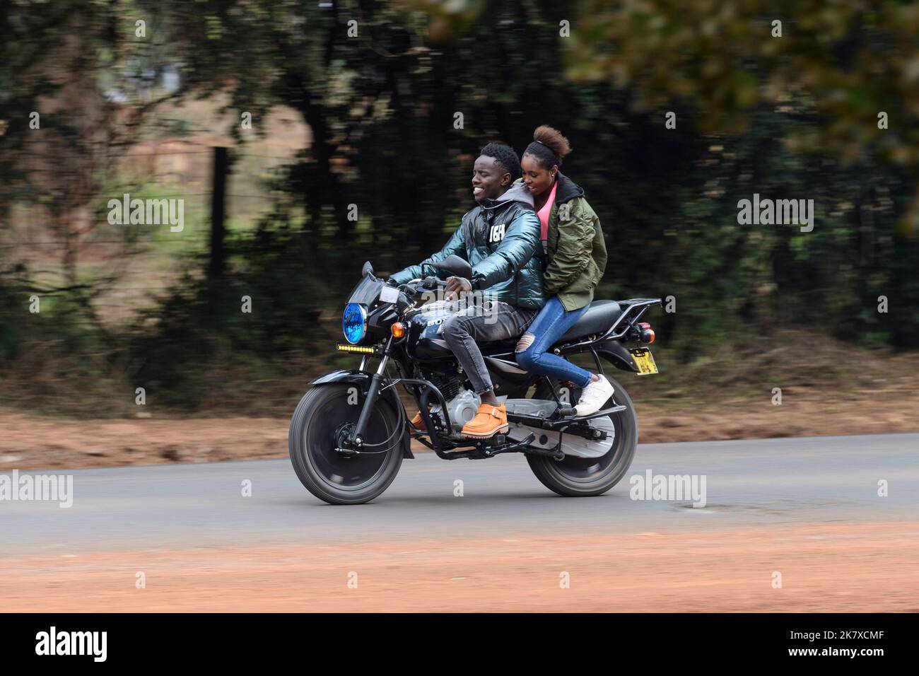 A pillion passenger riding on motorcycle taxis, know as a Boda boda, in ...