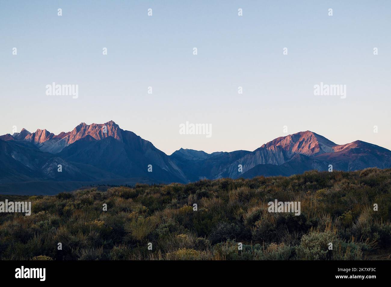 Dawn light illuminating a rugged mountain peak in the Eastern Sierra ...