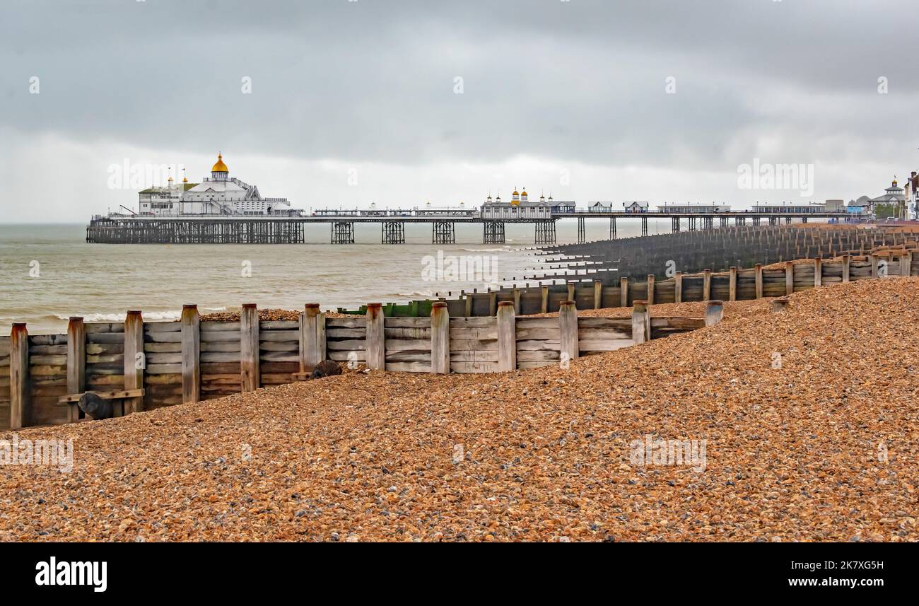 across the damp empty beach and rows of groynes to the pier at ...