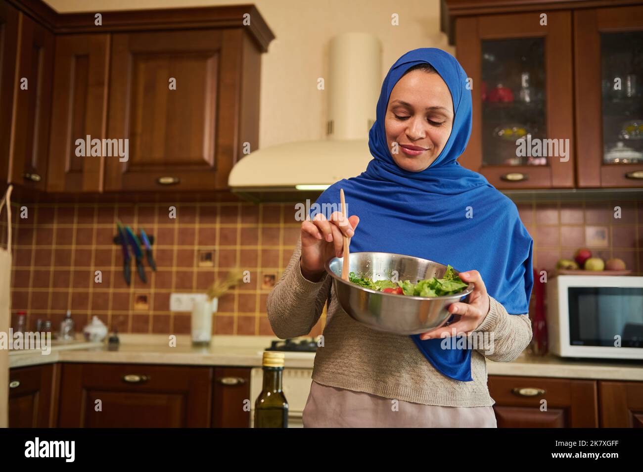Beautiful Middle-Eastern Muslim woman preparing healthy salad from ...
