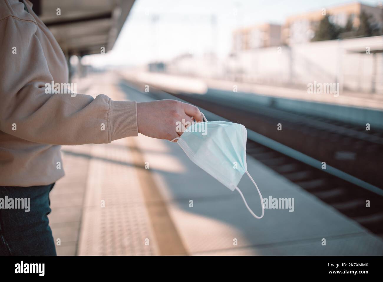 A hand raised a medical mask on the street. Take-off mask and deep ...