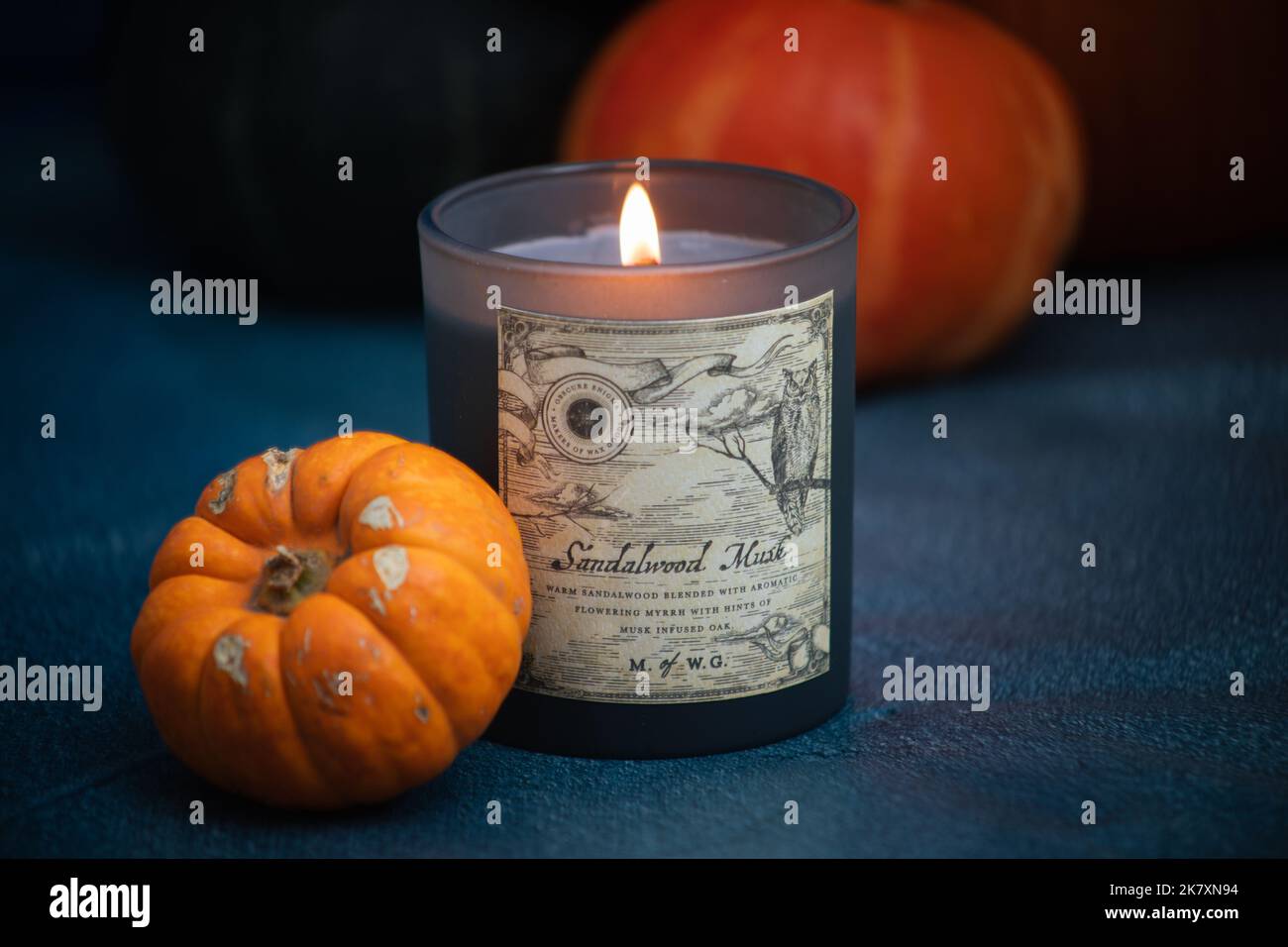 Lit Candle with pumpkins in background on blue Stock Photo - Alamy