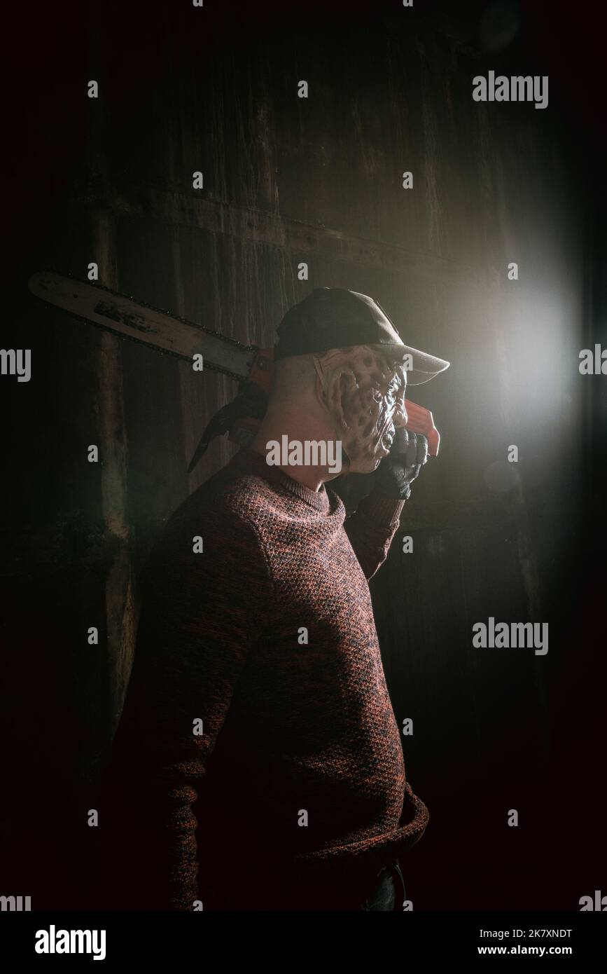 Evil in mask with chainsaw, horror Halloween scene in dark room Stock ...